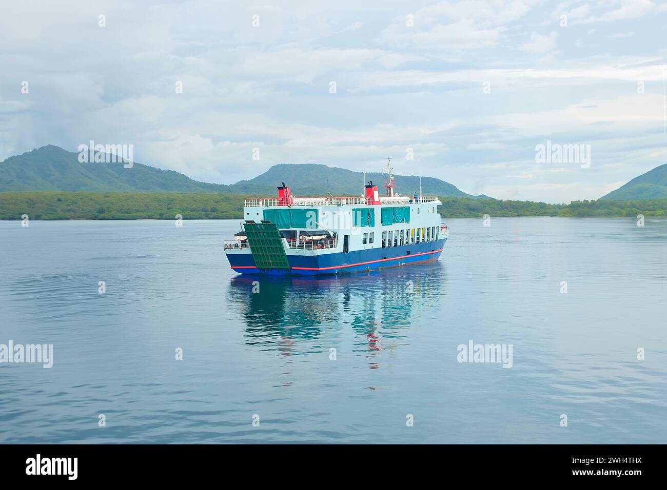 Passenger ship or ferry is sailing across the strait of Bali, Indonesia ...