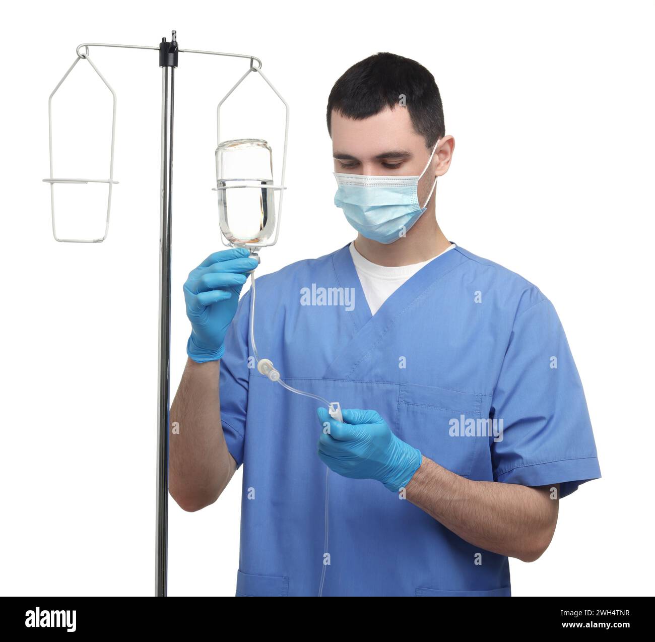 Nurse setting up IV drip on white background Stock Photo - Alamy