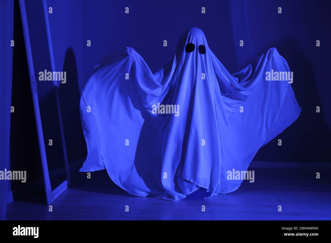 Creepy ghost. Woman covered with sheet in blue light Stock Photo - Alamy