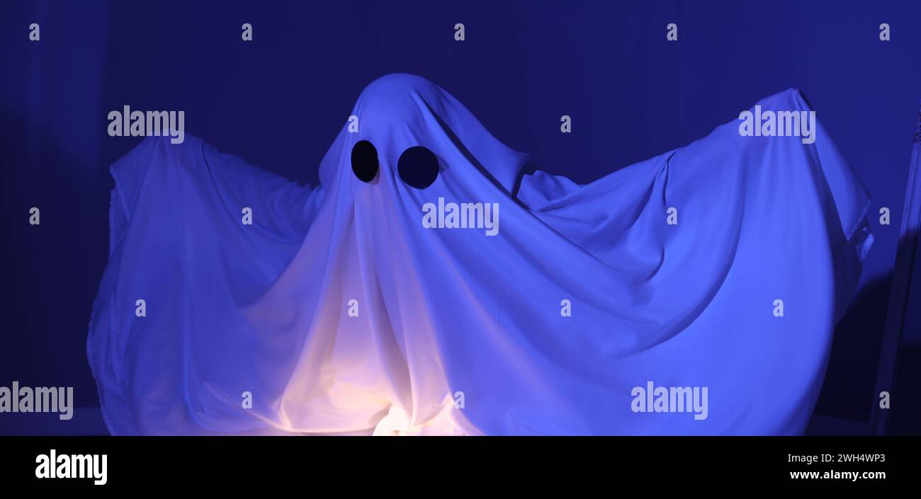 Creepy ghost. Woman covered with sheet in blue light Stock Photo - Alamy