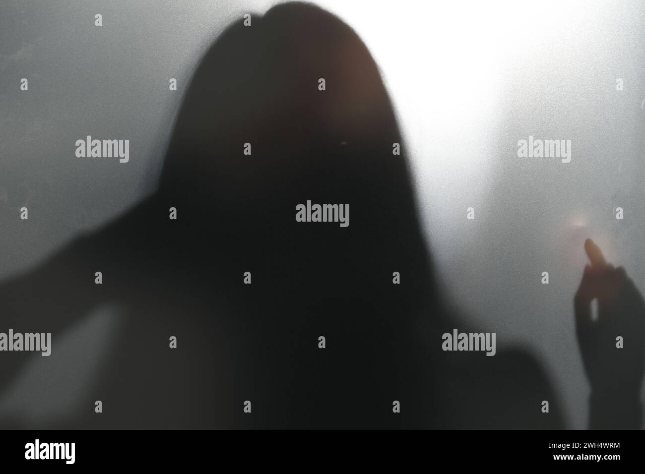 Silhouette of ghost behind glass against light grey background Stock ...