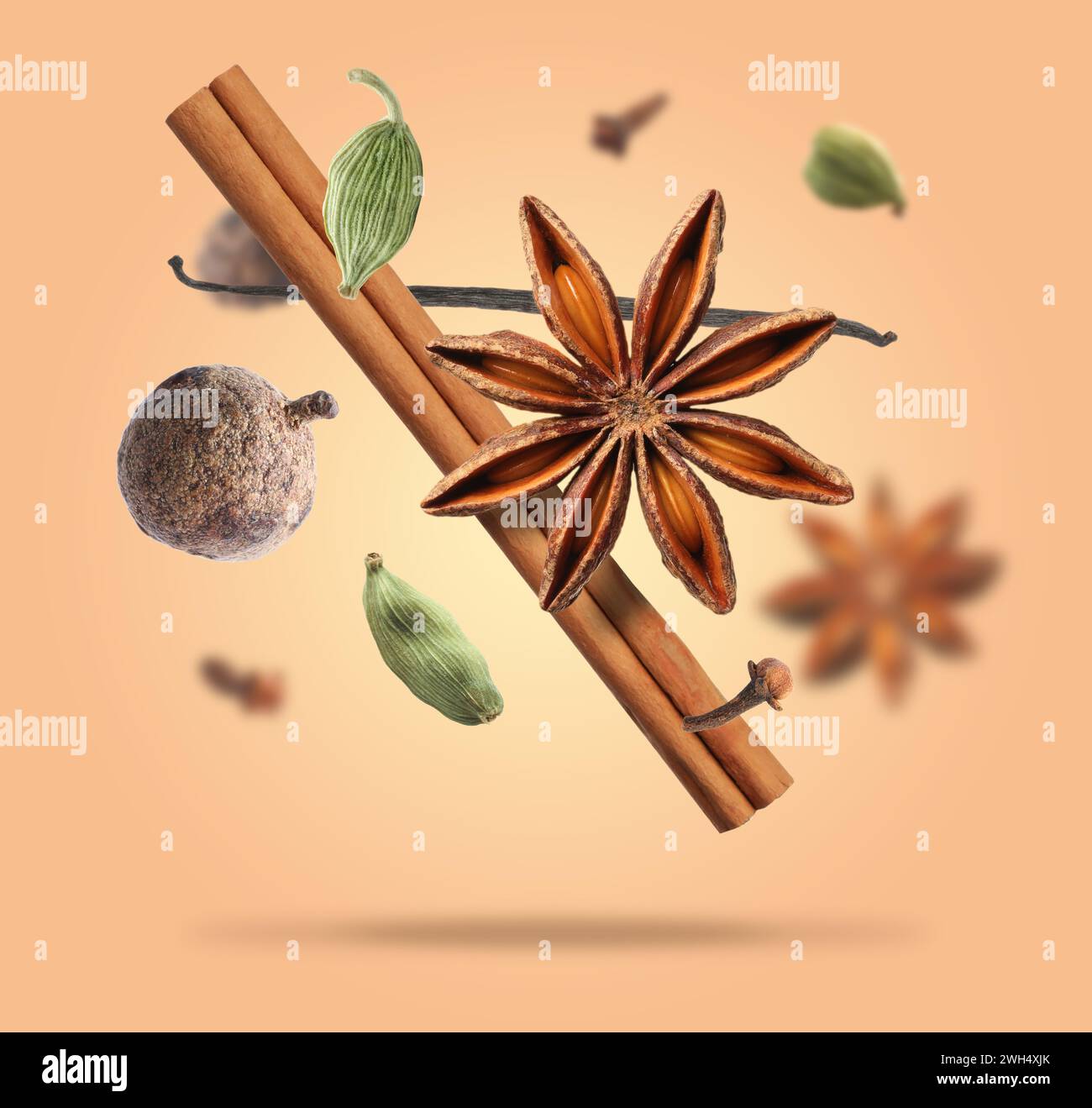 Different aromatic spices falling on pale orange background Stock Photo ...
