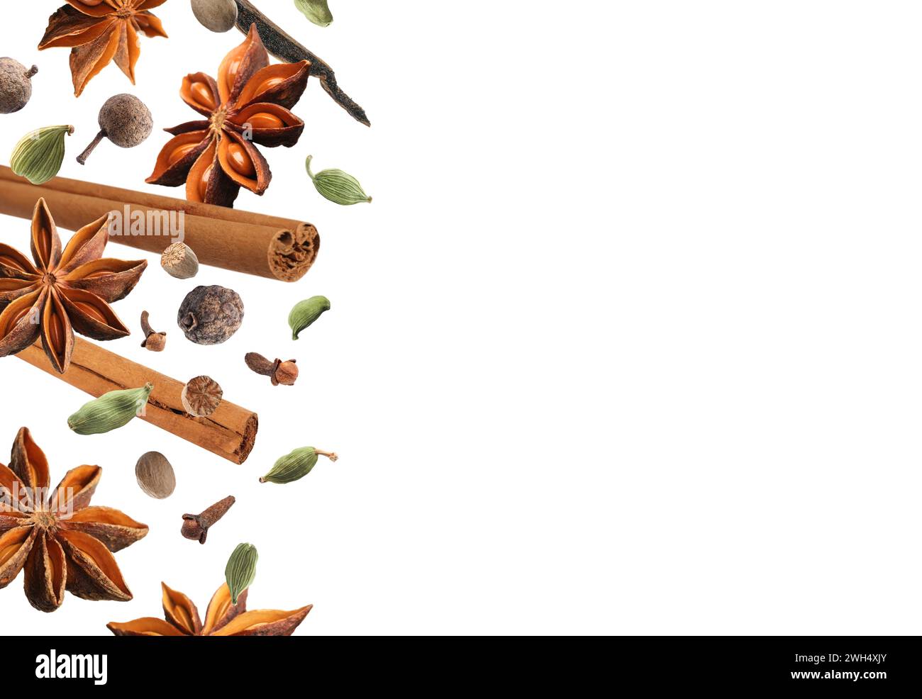 Different aromatic spices falling on white background Stock Photo - Alamy