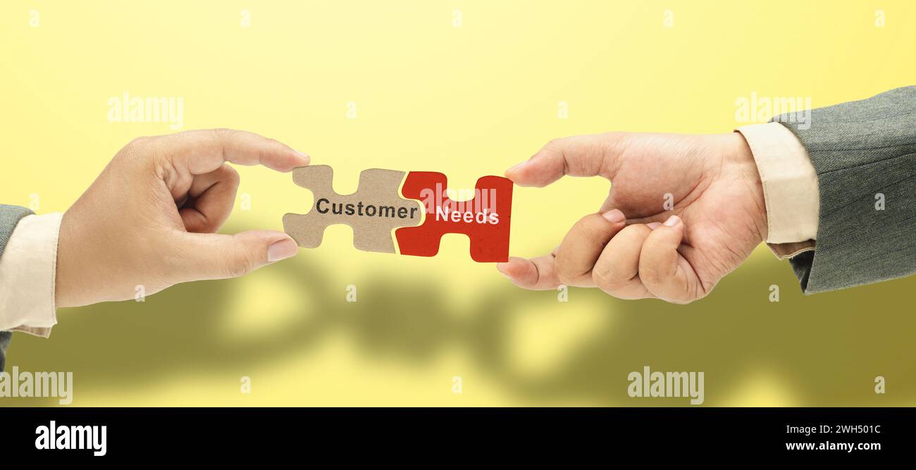 Two business hand holding pieces of a jigsaw puzzle with customer needs ...