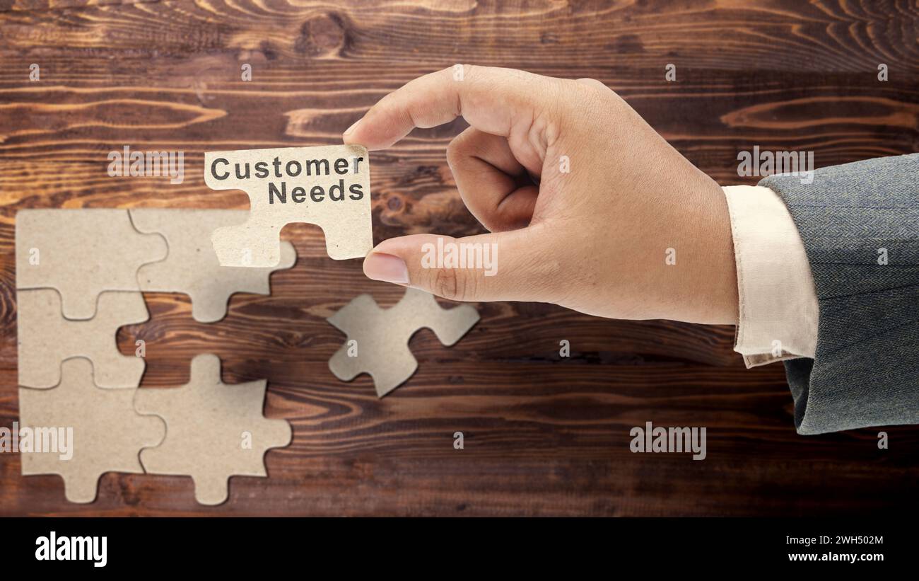 Business hand holding pieces of a jigsaw puzzle with customer needs ...