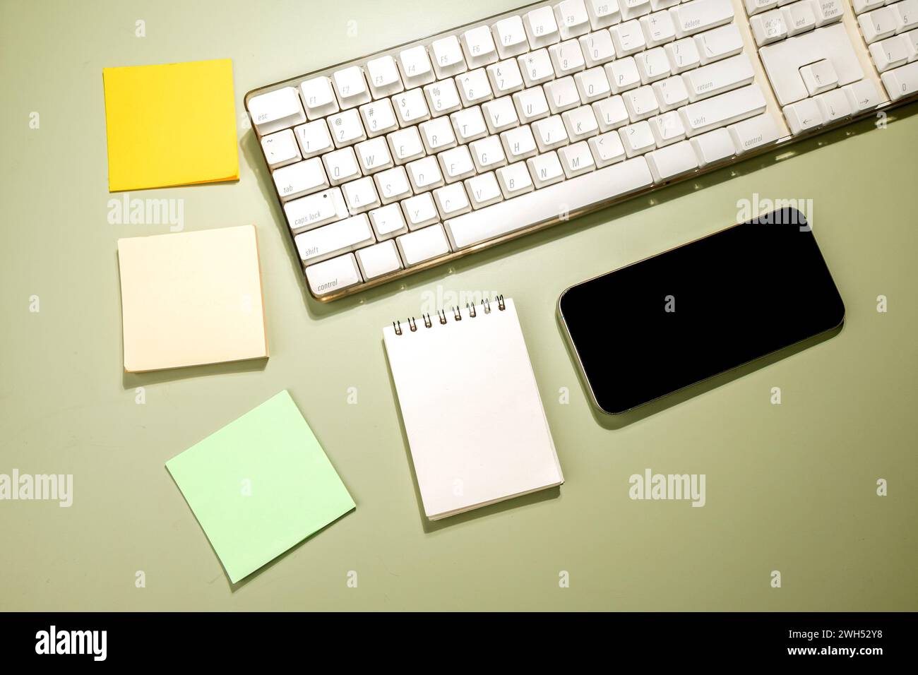 Closeup view of mobile phone with blank screen and an empty notebook ...