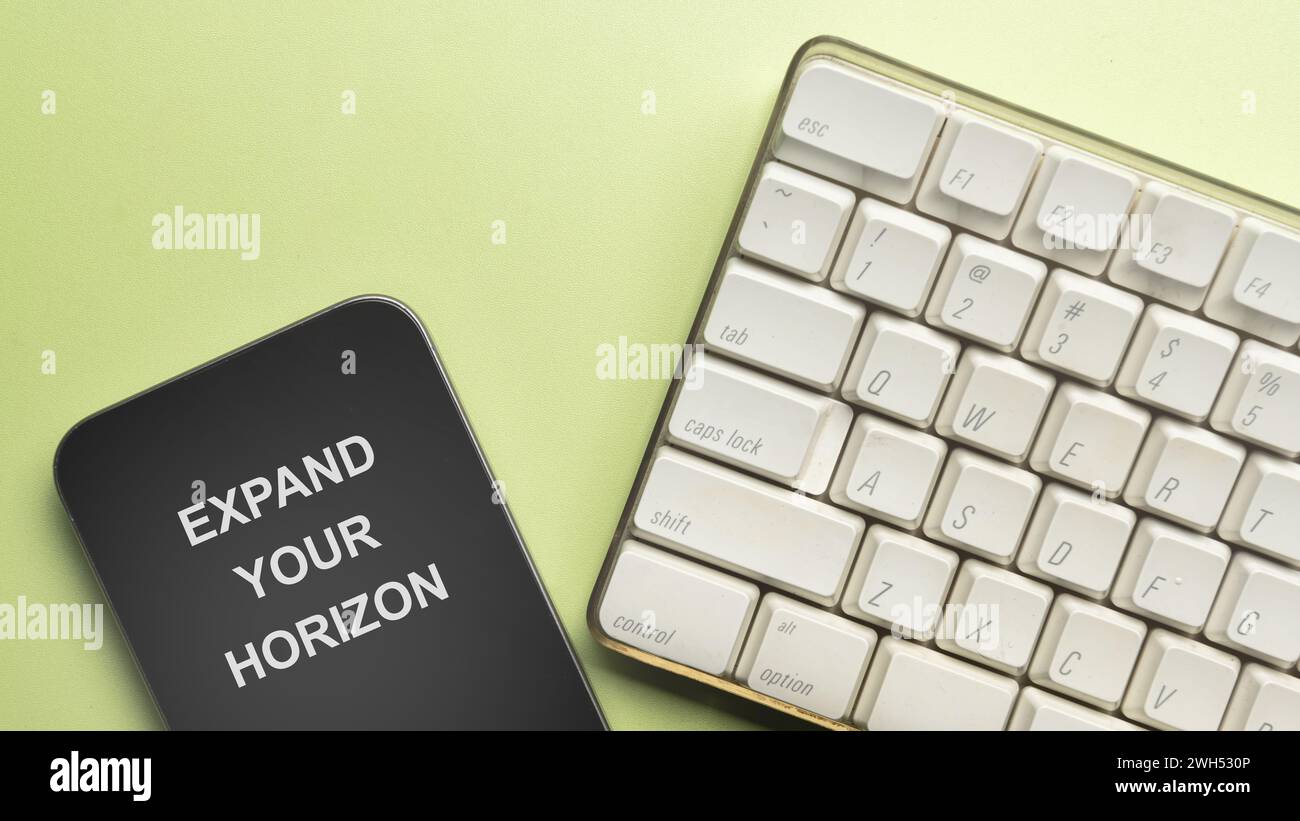 Mobile phone with 'Expand your horizon' text on the screen over a ...