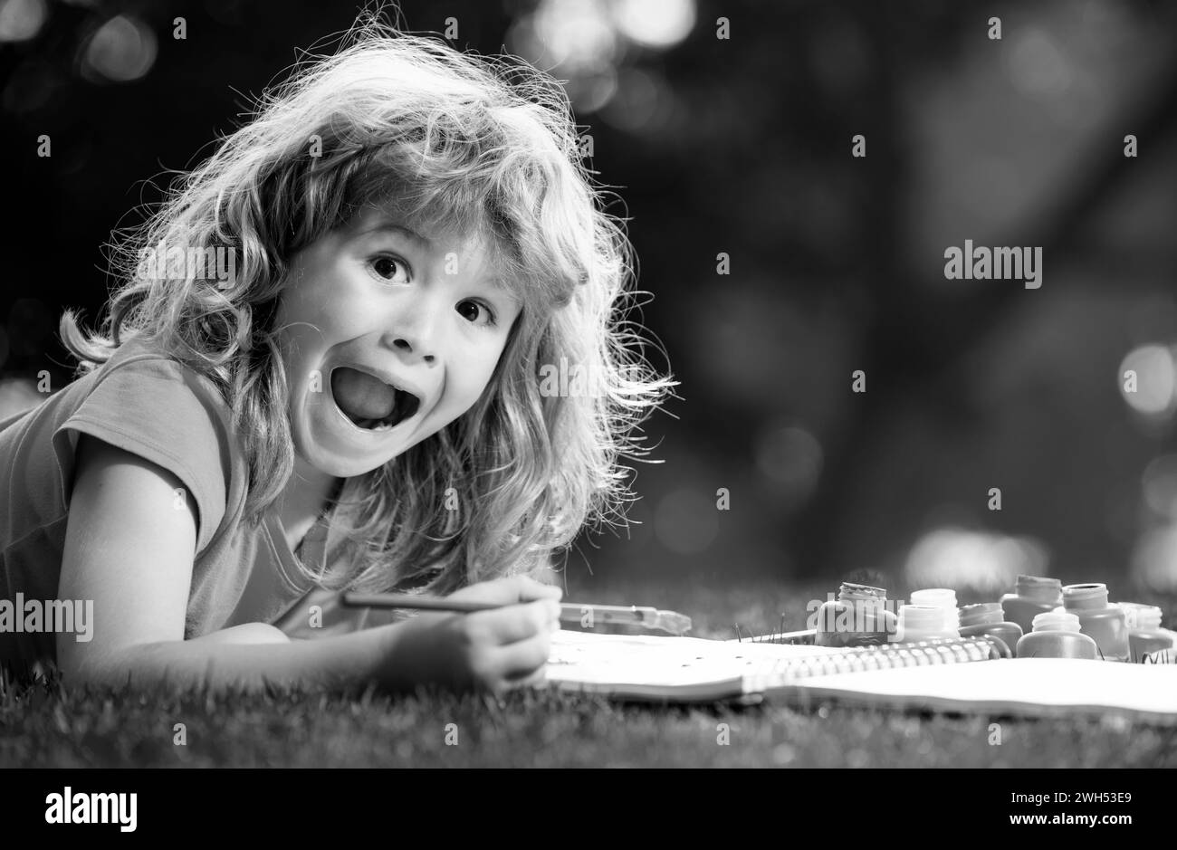 Excited kid painting in spring nature. Portrait of smiling happy kid ...