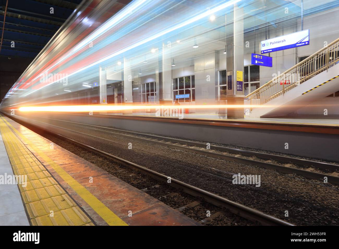 Slow, long exposure image of a fast train passing a train station in ...