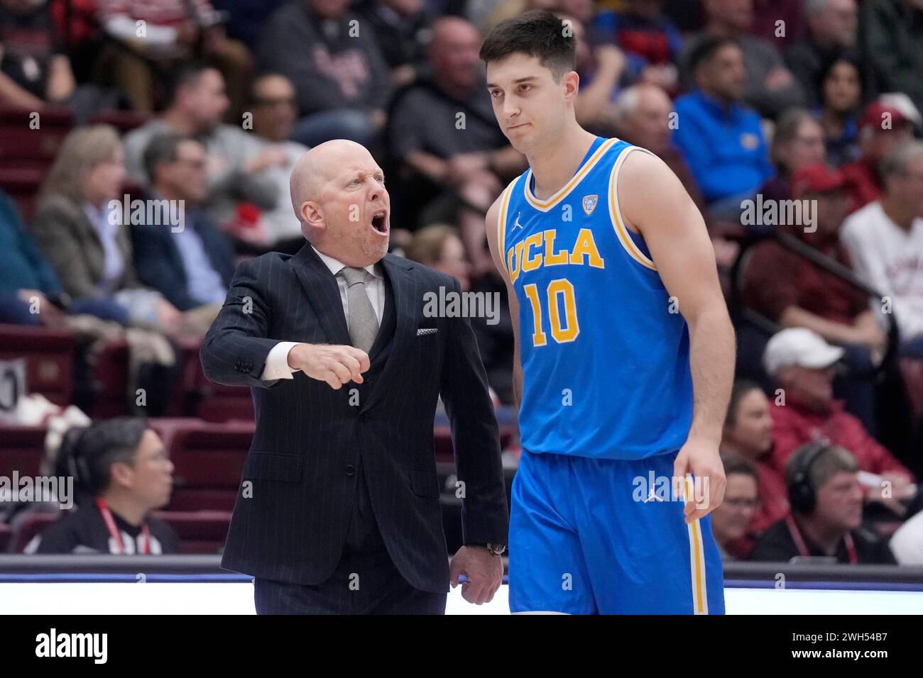 UCLA head coach Mick Cronin, left, gestures while talking to guard ...