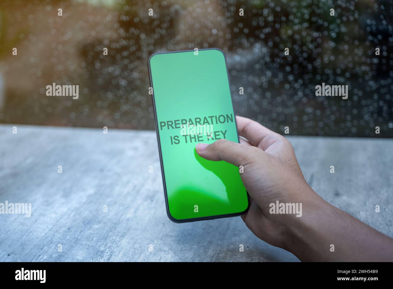 Human hand holding mobile phone with 'Preparation is the key' text on ...
