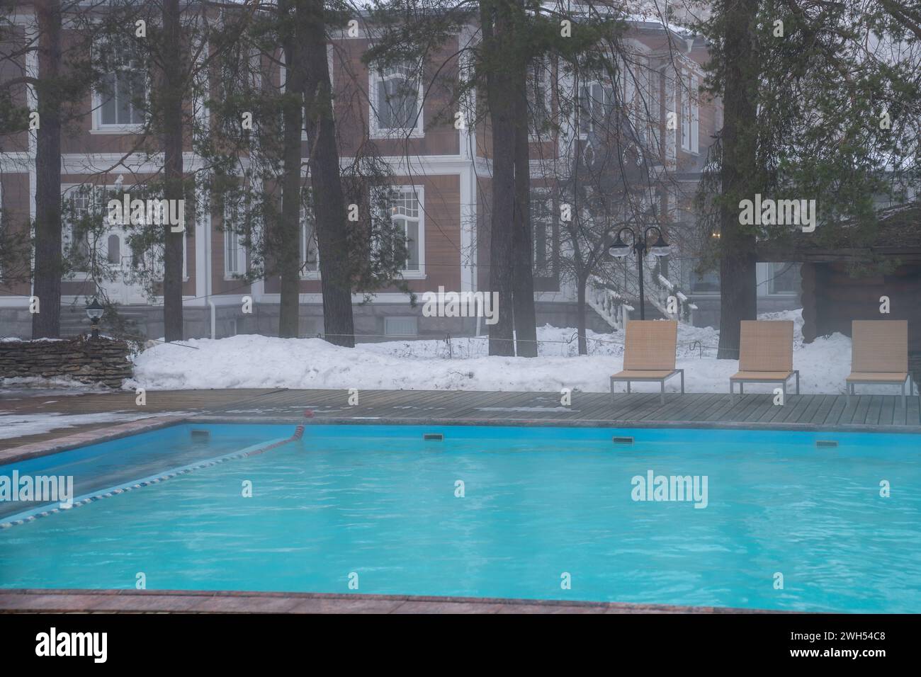 Open-air swimming pool with warm water. Winter wellness spa resort with ...