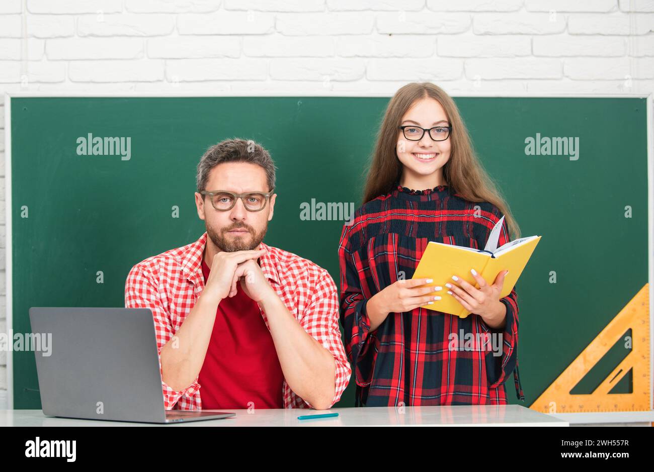 Teacher explains lesson to school child. Elementary school kids ...