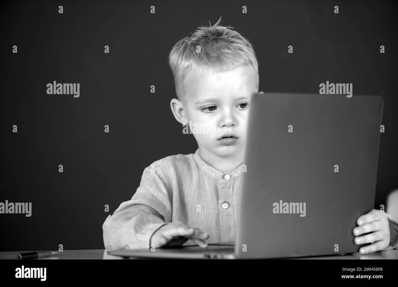 Elementary school kid working in computer class. Cute pupil face closeup on blackboard ...