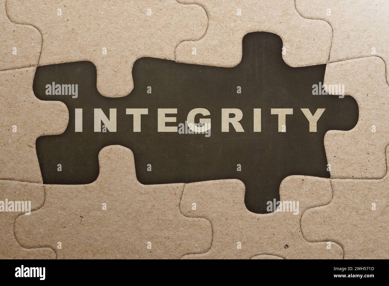 Piece of missing jigsaw puzzle with integrity text on a black ...
