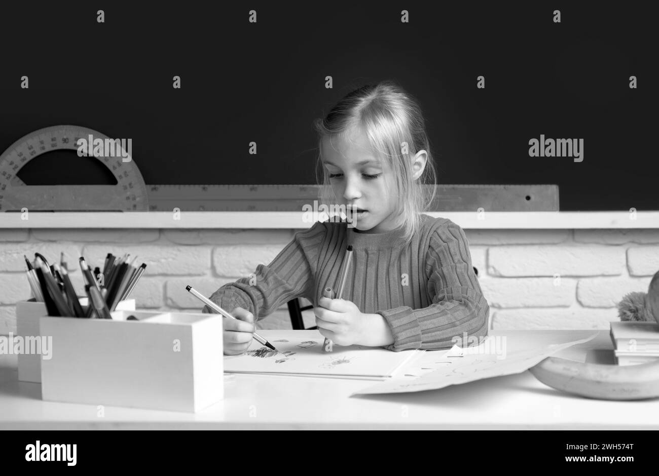 Back to school. Cute pupil girl drawing at the desk. Genius child ...