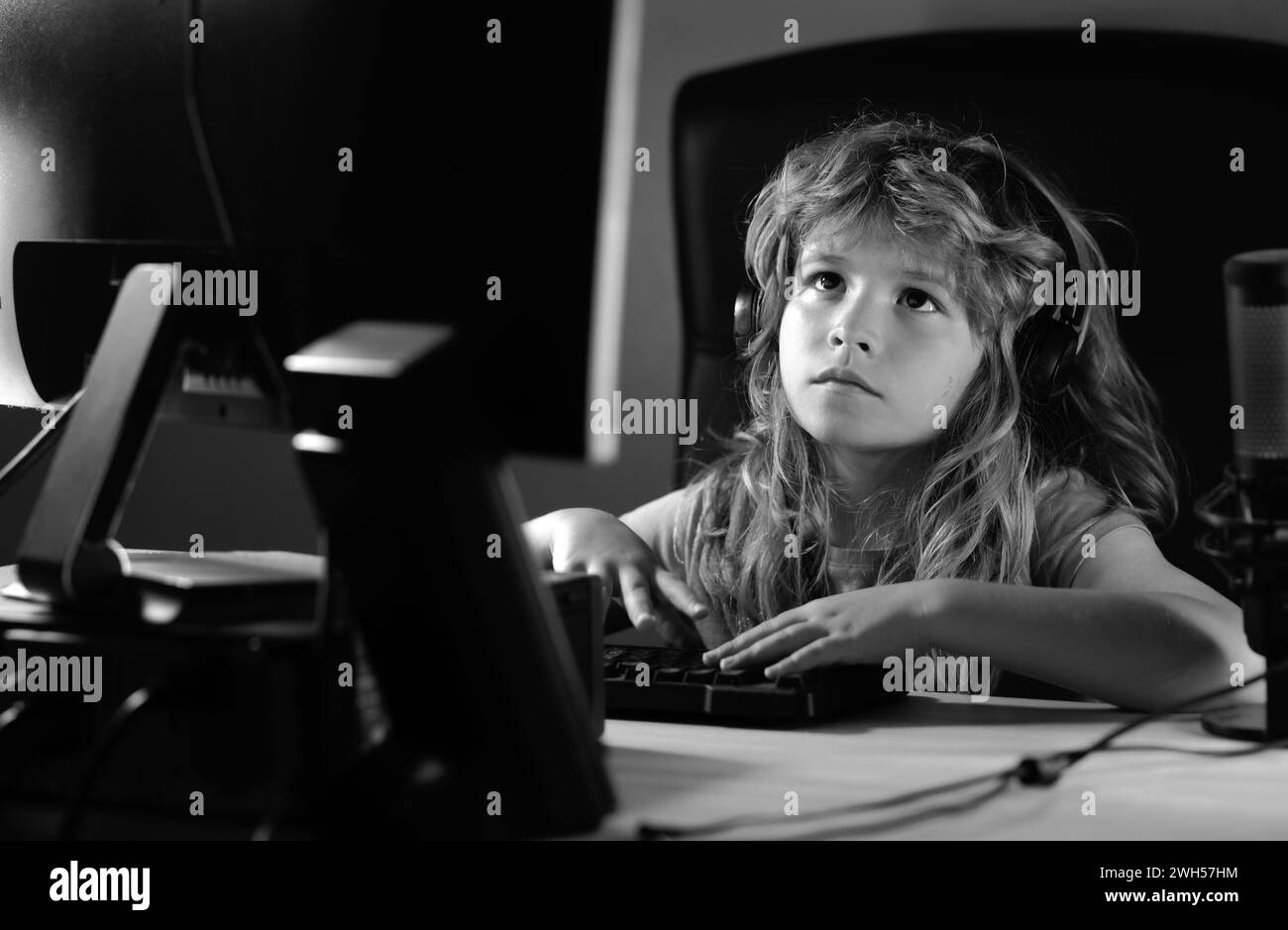 A little boy child uses a desktop at night, a child with computer ...