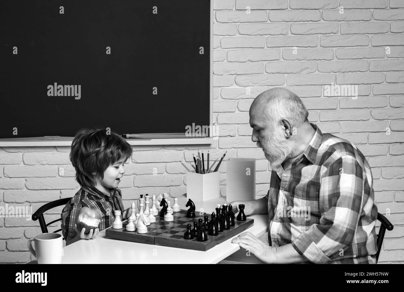 Grandfather and grandson boy playing chess, men generation. Different ...