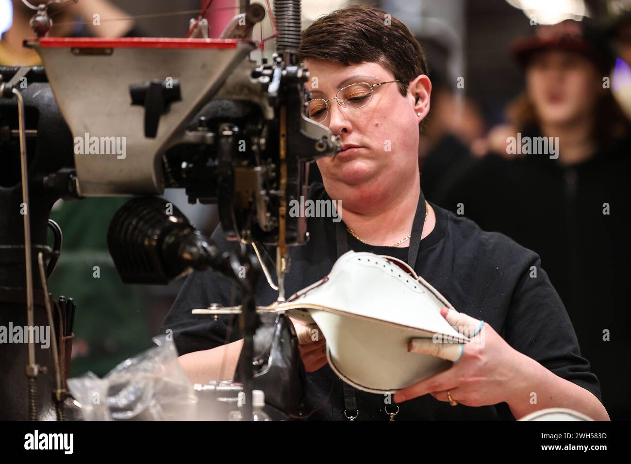 February 07, 2024: A worker at the Wilson booth sews together panels ...