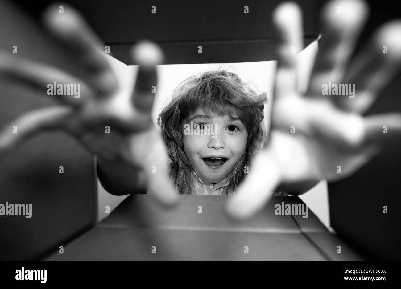 Child looking inside cardboard box, bottom view. Delivering your ...