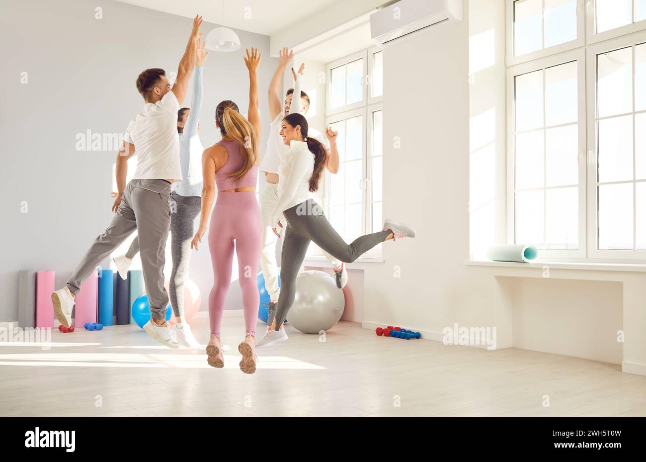 Group high five jump, young sporty happy people and coach greeting ...