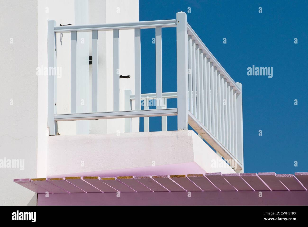 A white balcony railing against a blue sky background Stock Photo - Alamy