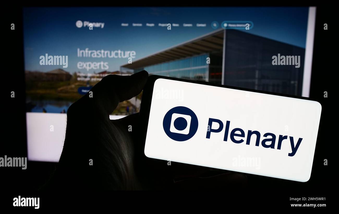 Person holding mobile phone with logo of Australian infrastructure ...