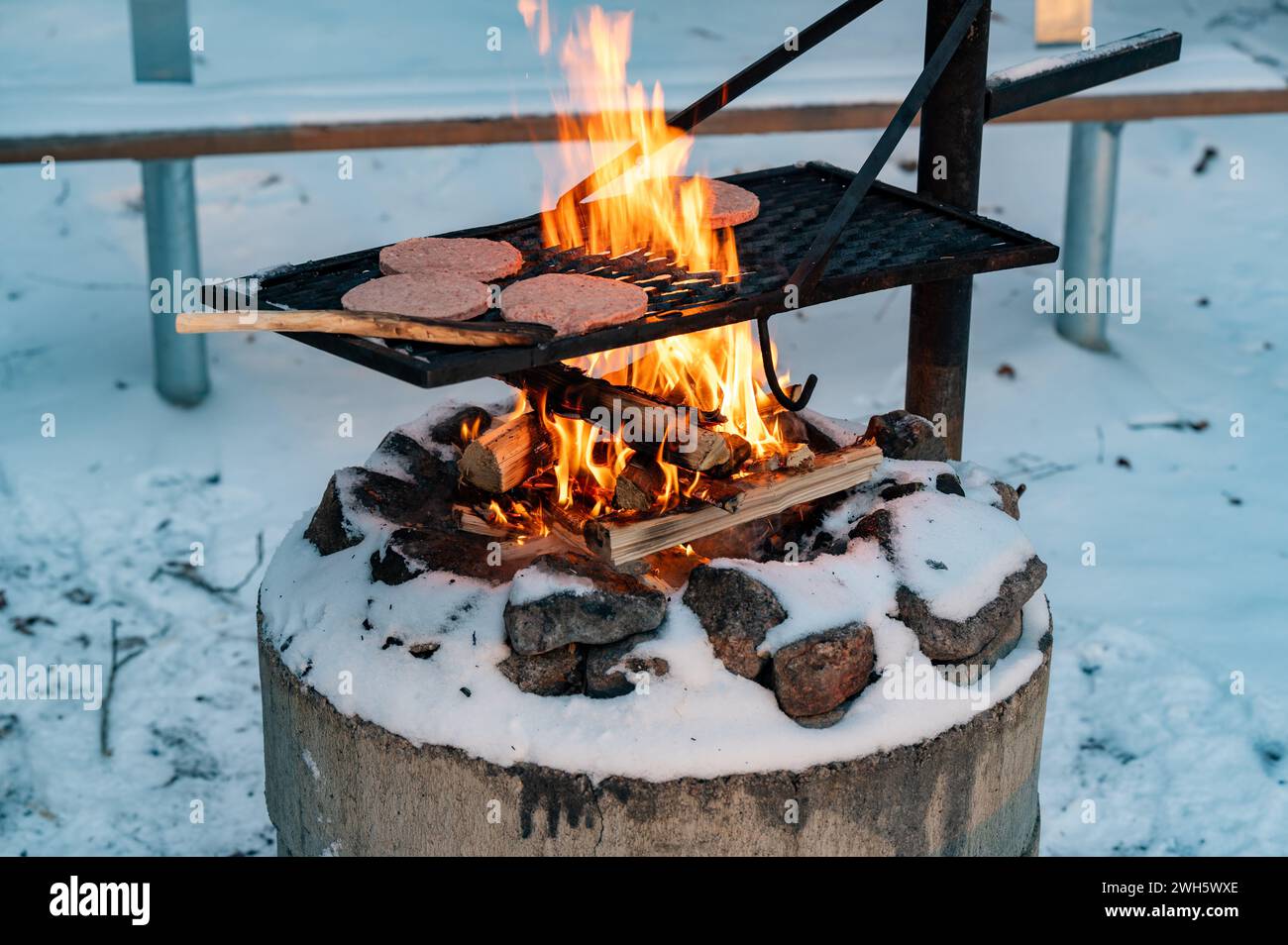Hamburger on cooking grate over big flames Stock Photo - Alamy