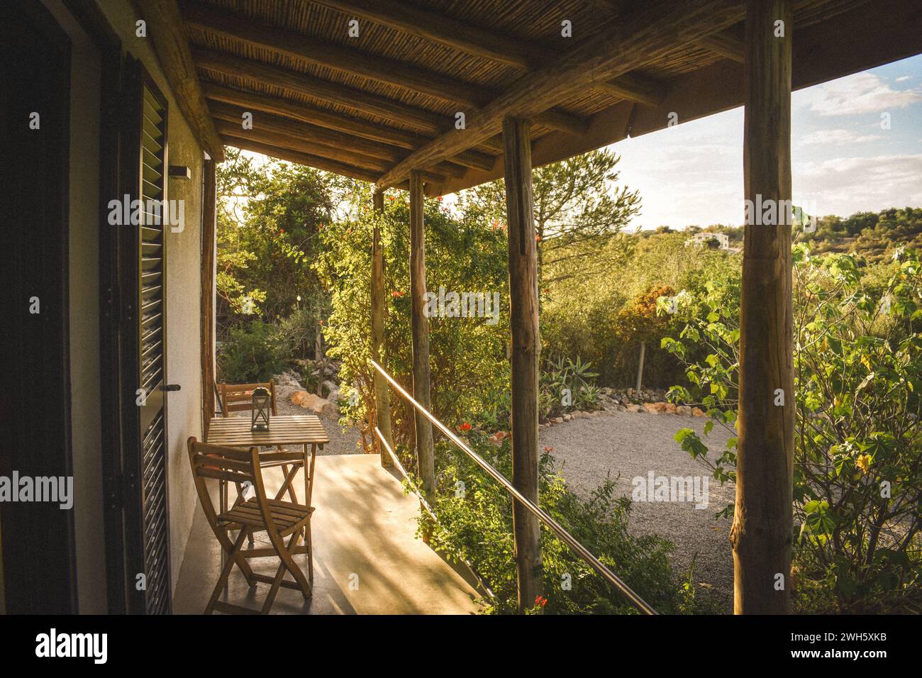 A charming outdoor veranda with stylish furniture set amidst lush trees ...