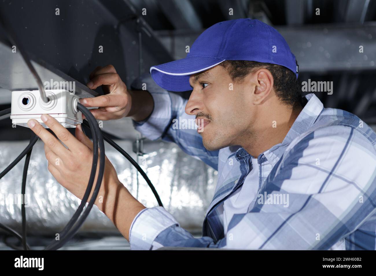 engineer working with cables in the roof Stock Photo - Alamy