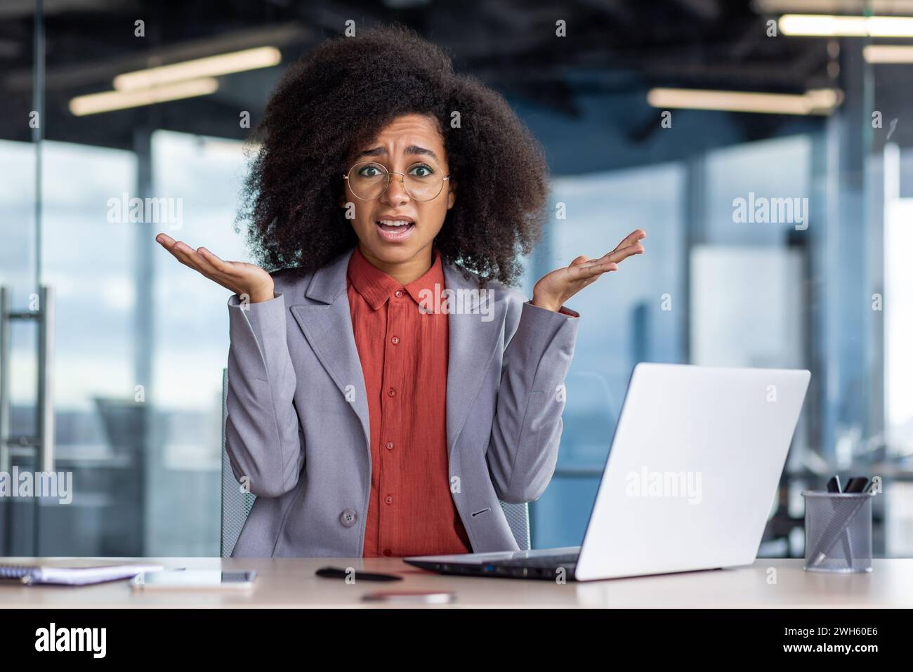 Perplexed African American businesswoman with curly hair expressing ...