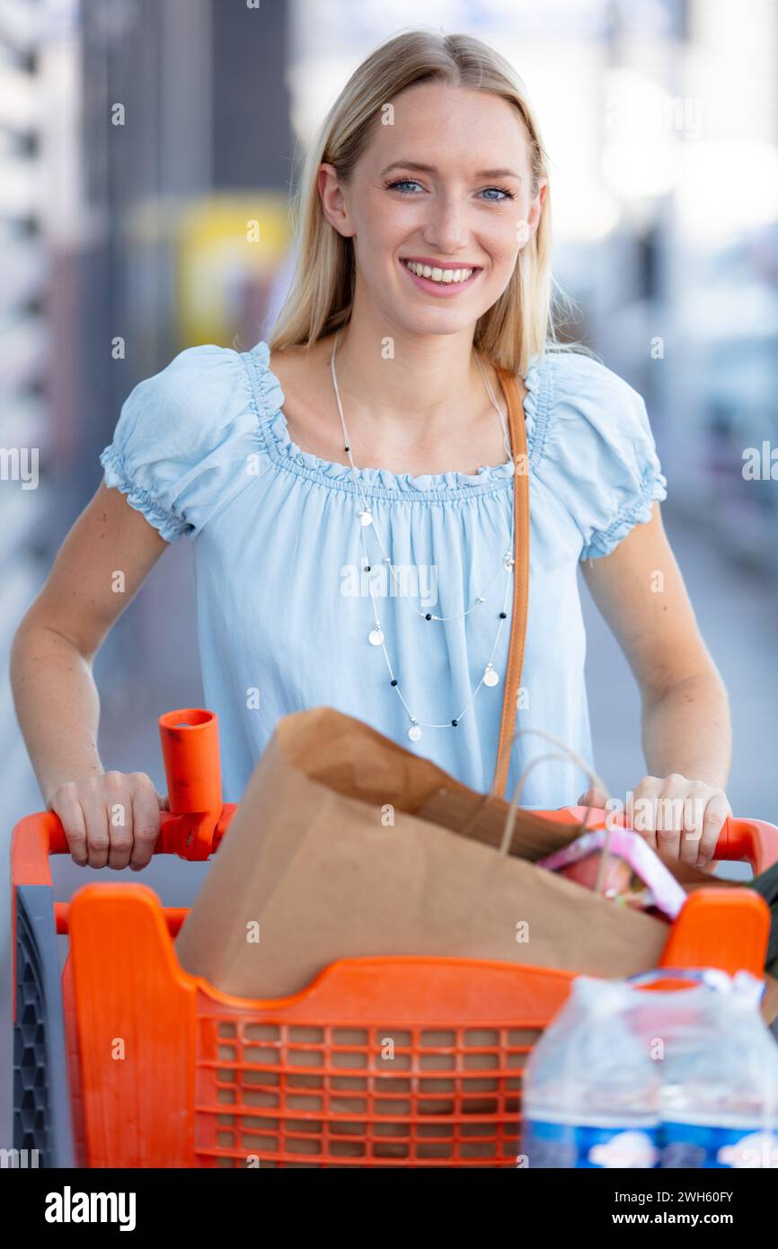 beautiful woman pushing a shopping cart Stock Photo - Alamy