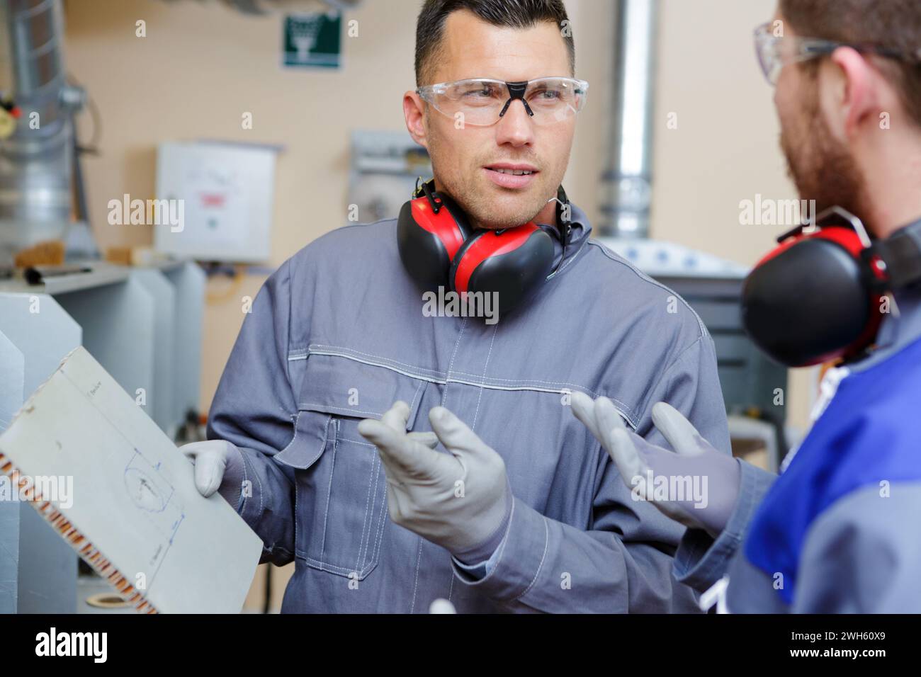 carpenter showing apprentice a drawing Stock Photo - Alamy