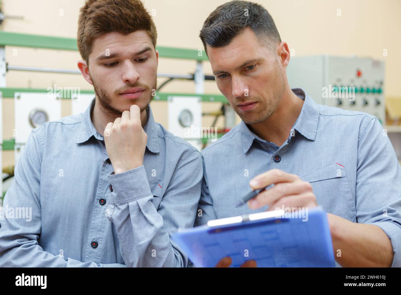 portrait of workers checking clipboard Stock Photo - Alamy