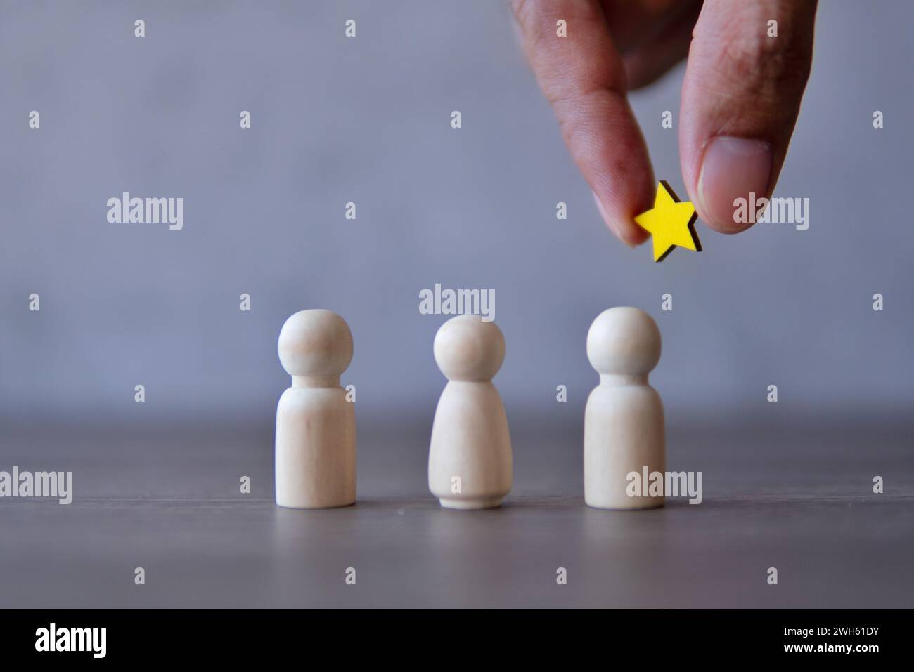 Hand holding a star over the team. Awarding, appreciation and reward ...