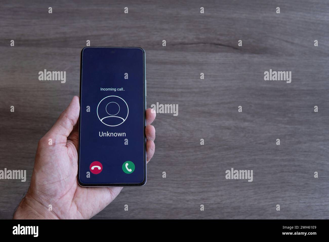 Top view image of hand holding smartphone and unknown incoming phone ...