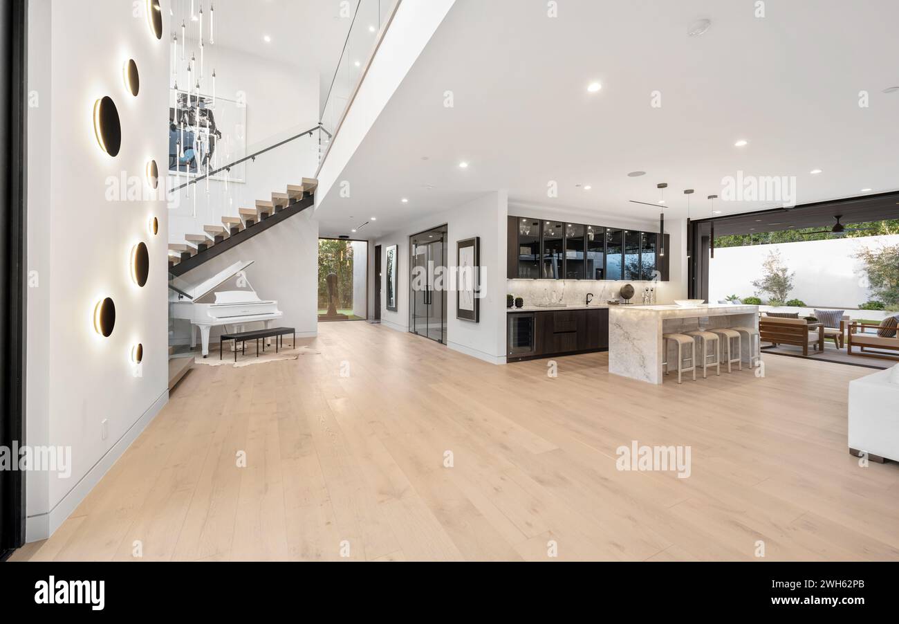 A contemporary living room with a staircase and white marble countertop ...
