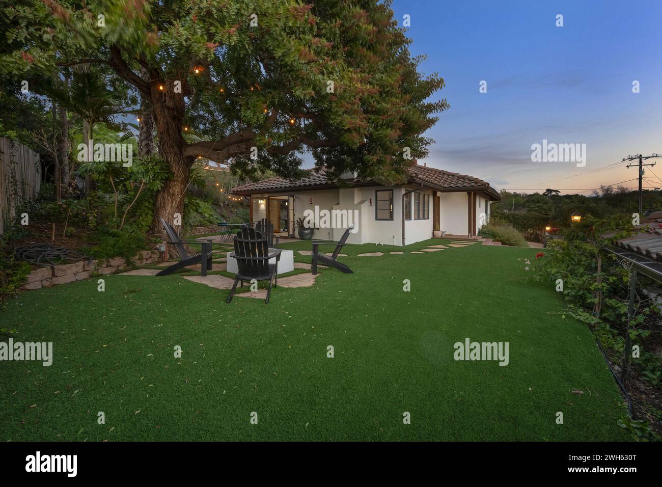 A spacious backyard with a green lawn and sitting area Stock Photo - Alamy