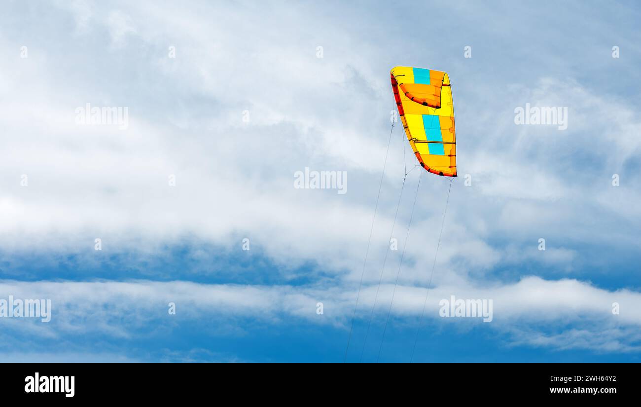 Colorful paraglider against the blue sky. Paraglider sail preparing to ...
