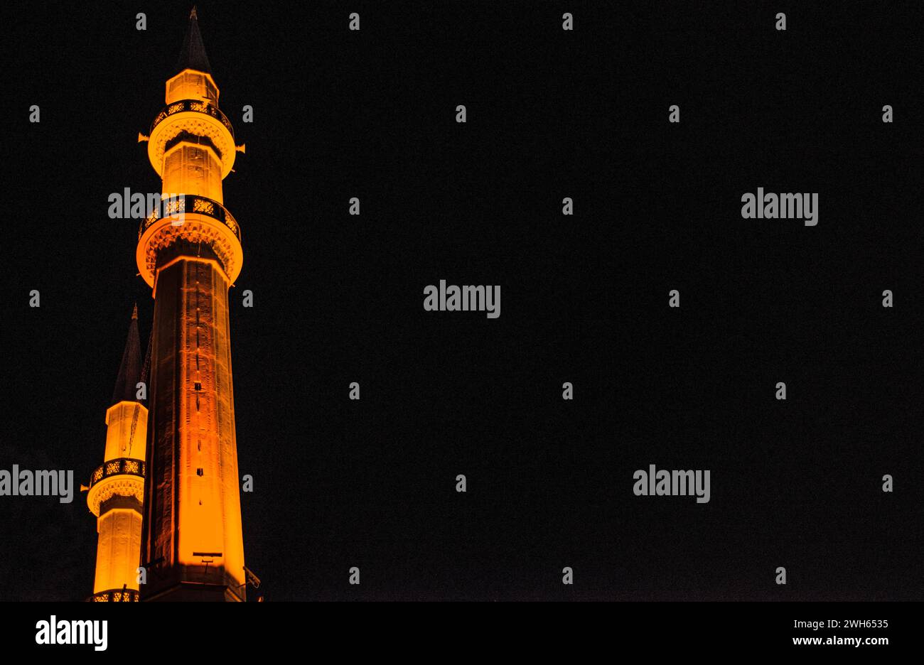 An enchanting view of a minaret with lights at night, illuminating the ...