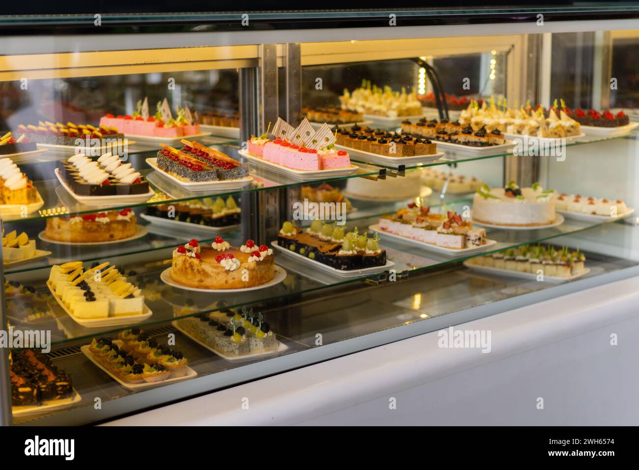 Showcase with sweets. Various desserts and cakes for sale Stock Photo ...