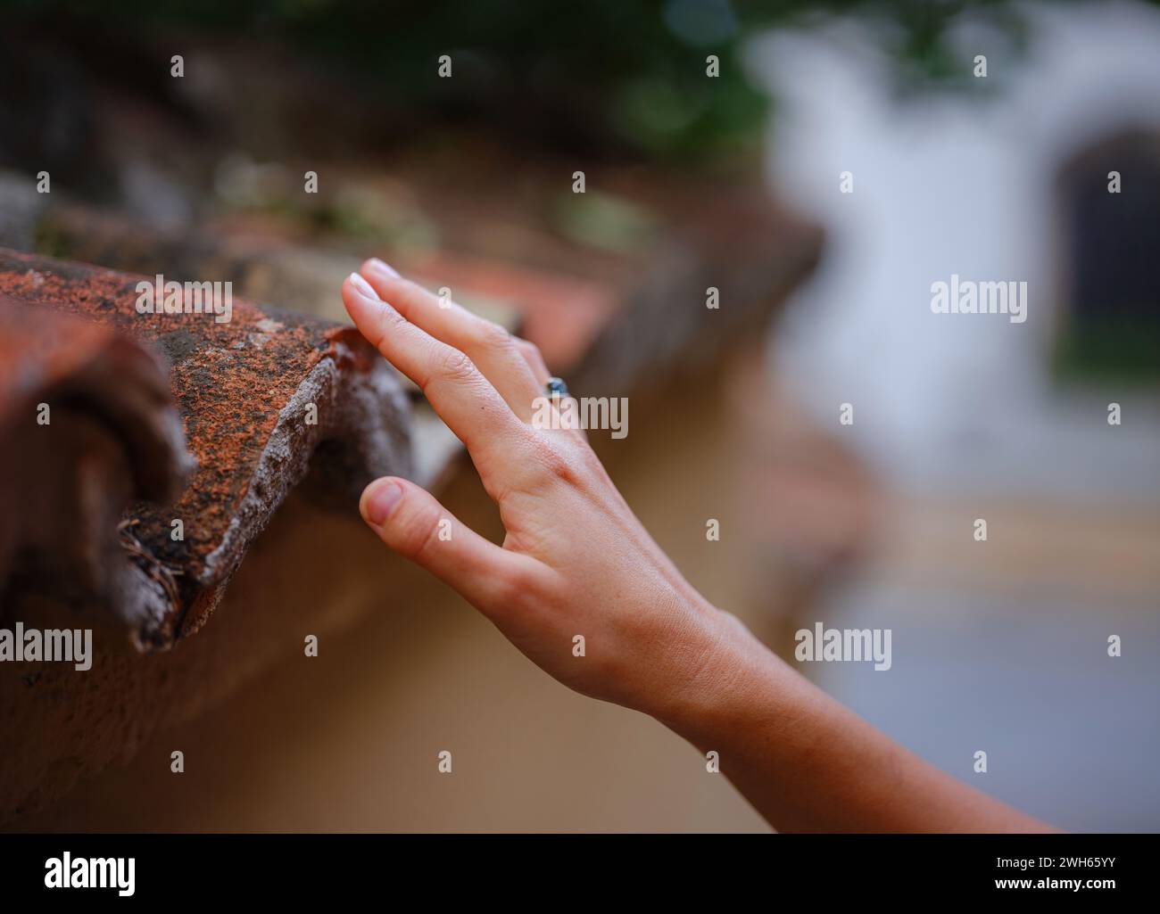 Female hand gently touches weathered tiles in old town of Kalechi ...