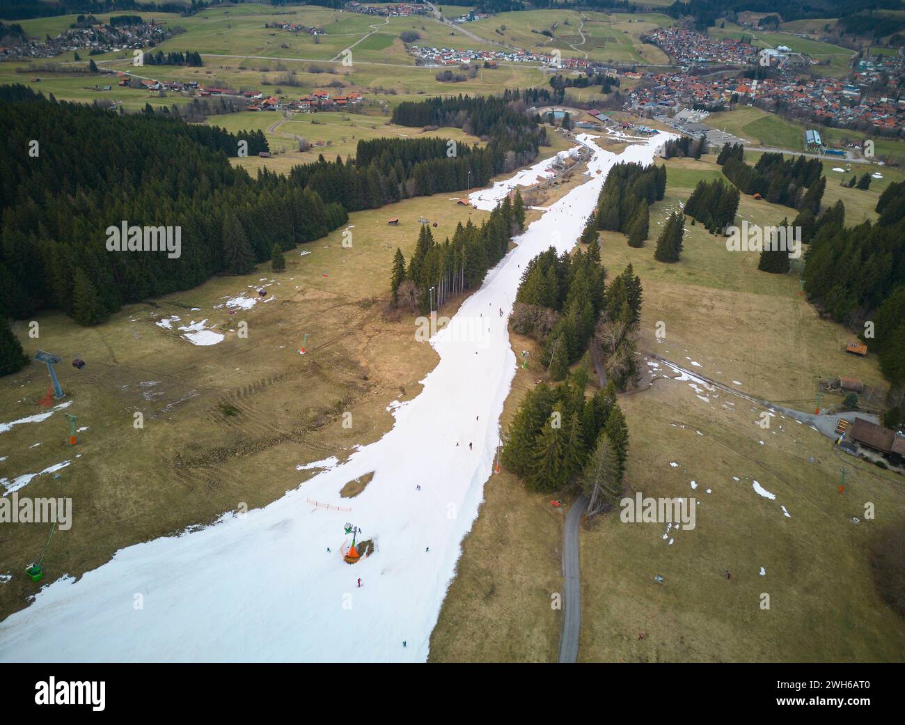 Alpine skiing on the ski slope in warm temperatures and lack of snow at ...