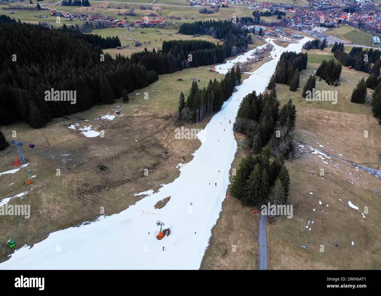 Alpine skiing on the ski slope in warm temperatures and lack of snow at ...