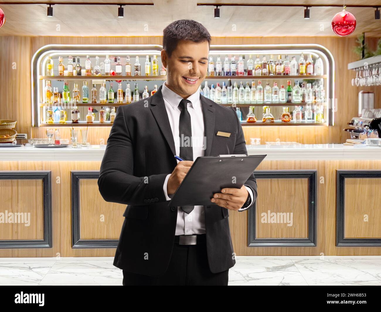 Manager writing a document at a bar Stock Photo - Alamy