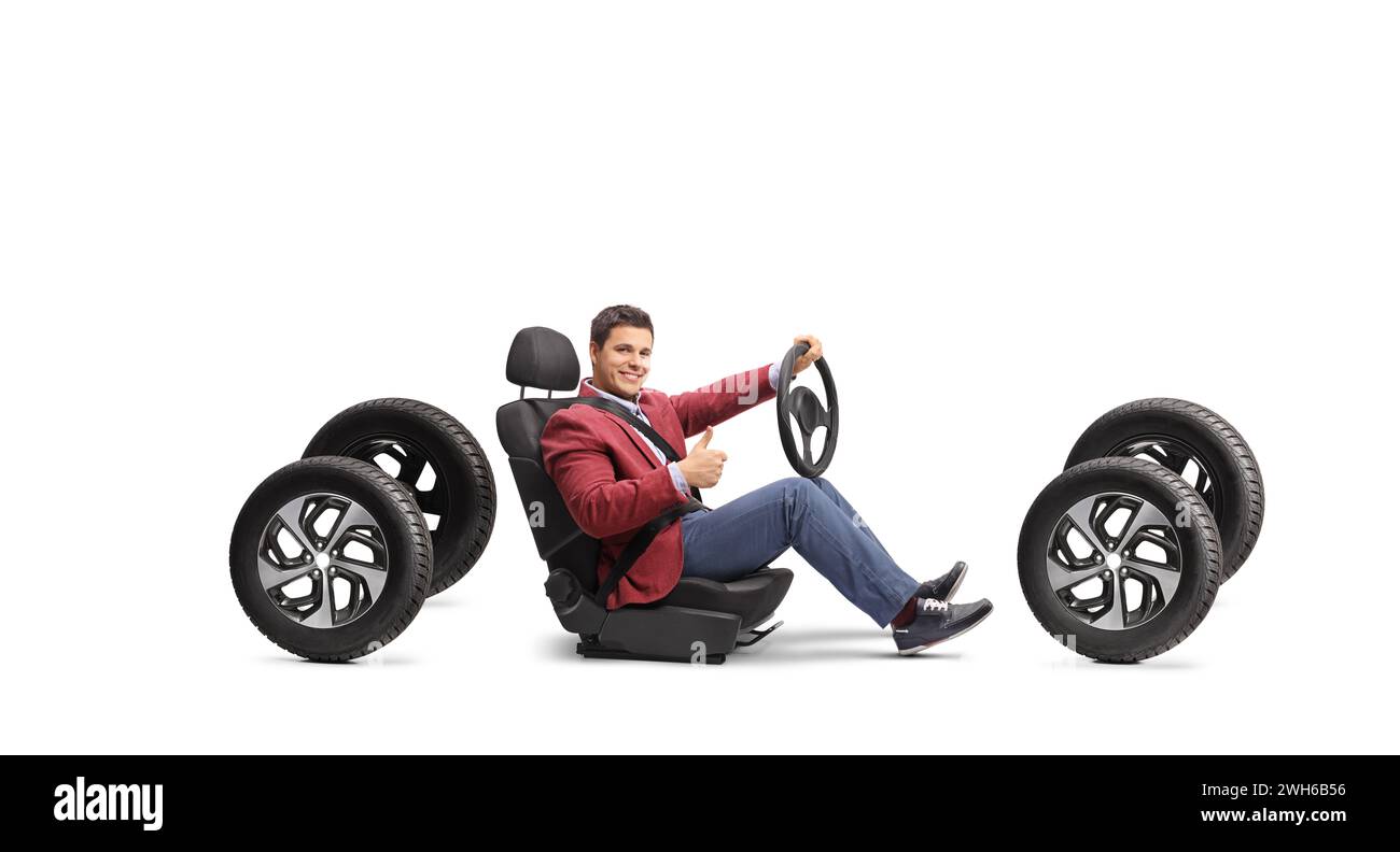 Man holding a steering wheel and gesturing thumbs up, car seat and four ...