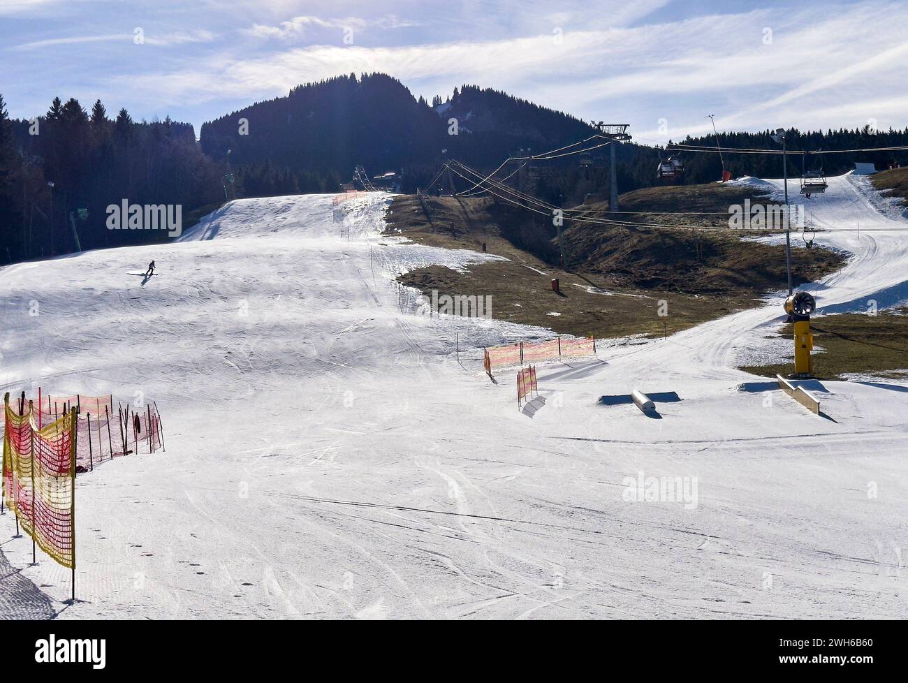 Alpine skiing on the ski slope in warm temperatures and lack of snow at ...