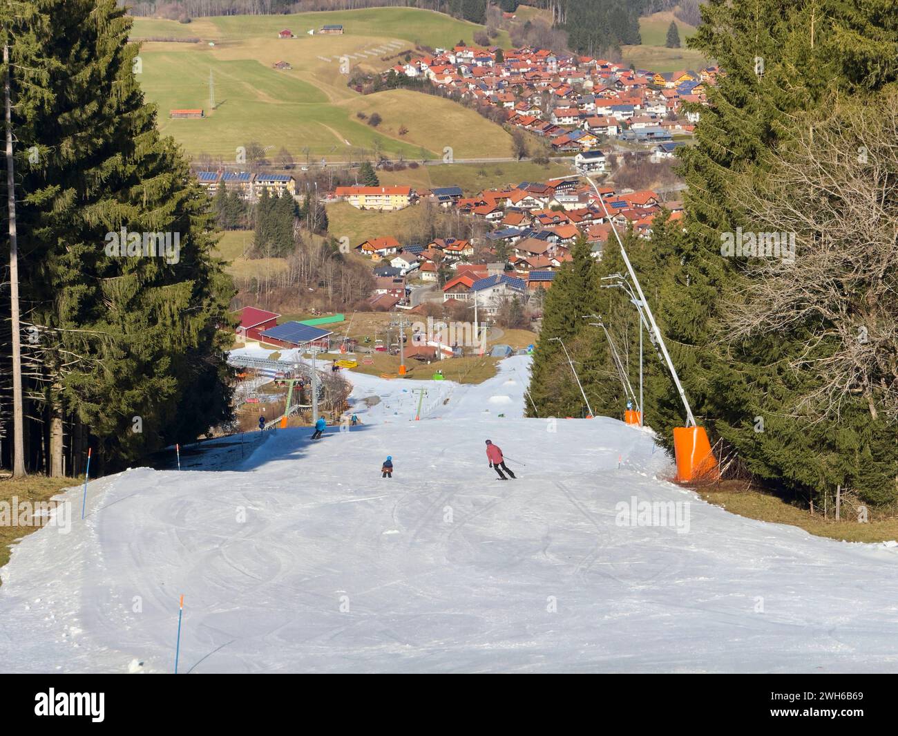 Alpine skiing on the ski slope in warm temperatures and lack of snow at ...