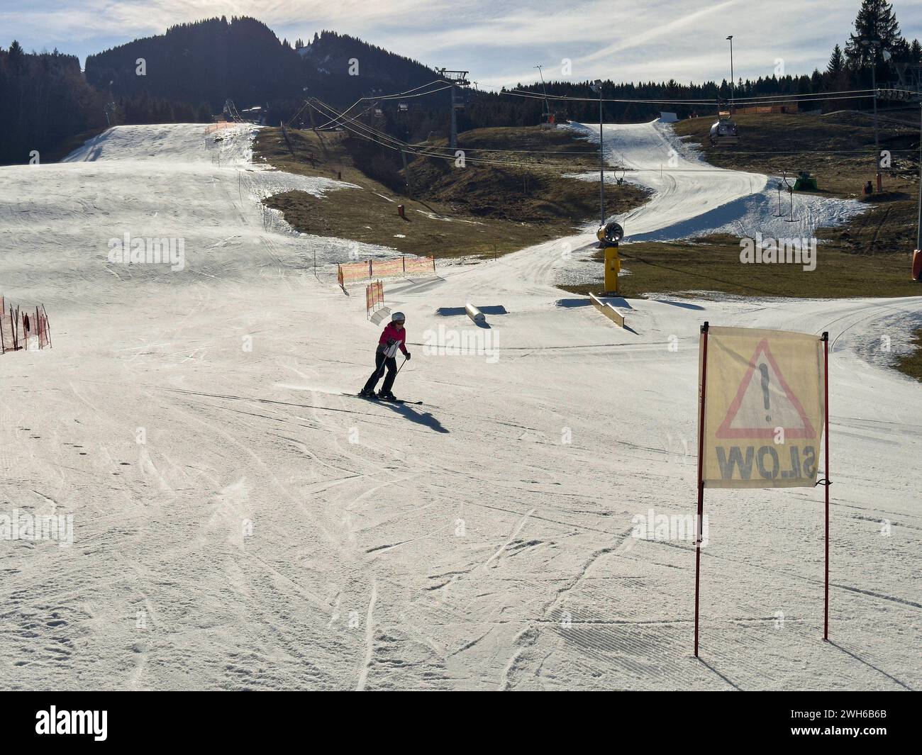 Alpine skiing on the ski slope in warm temperatures and lack of snow at ...