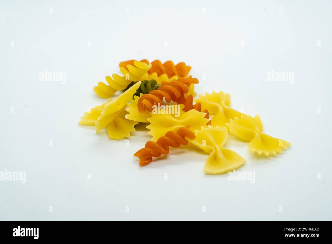 The assorted colored pasta varieties arranged on a pristine white ...